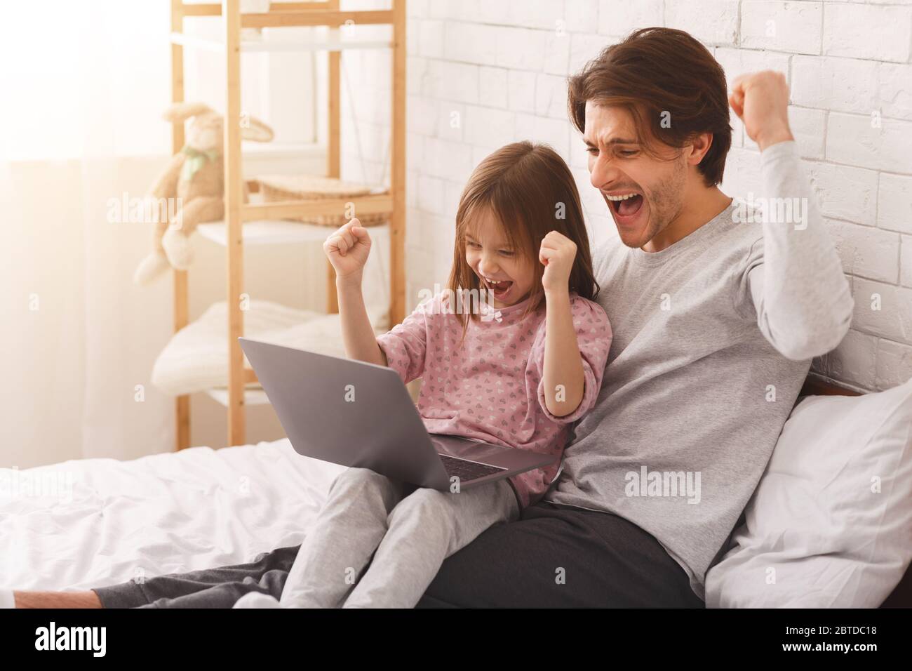 Emotional father and daughter playing computer games Stock Photo - Alamy