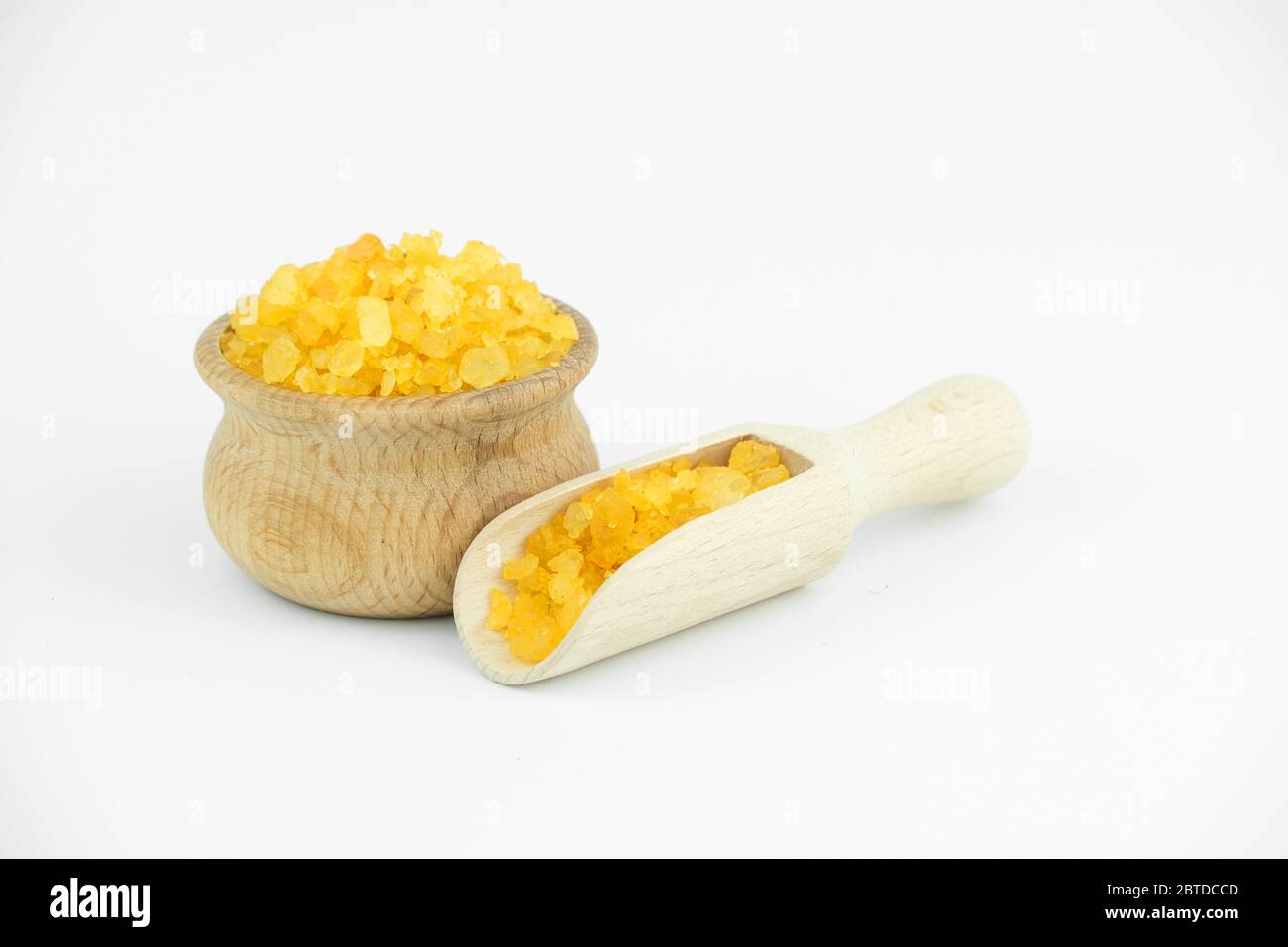 Yellow sea spa salt in wood bowl with a wood scoop isolated on white ...