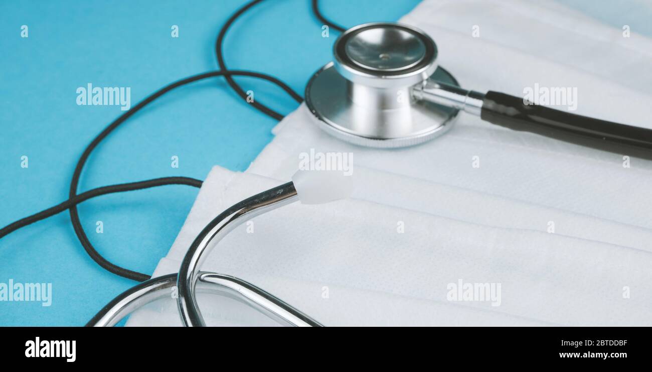 Hand made white medicine mask and stethoscope on blue background Stock ...