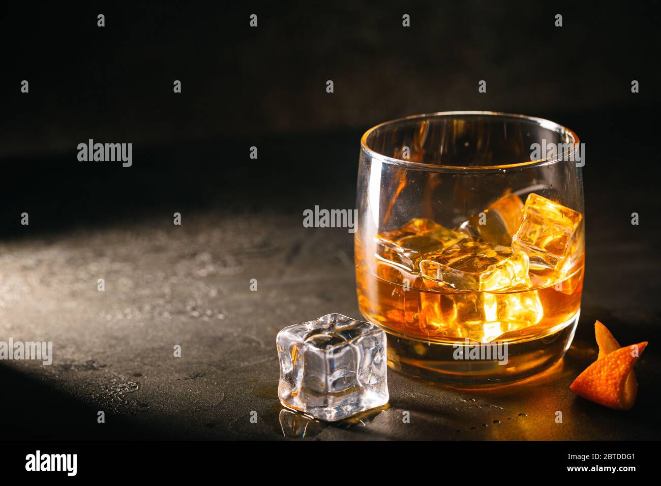 Glass of scotch whiskey with ice cubes on black background Stock Photo ...