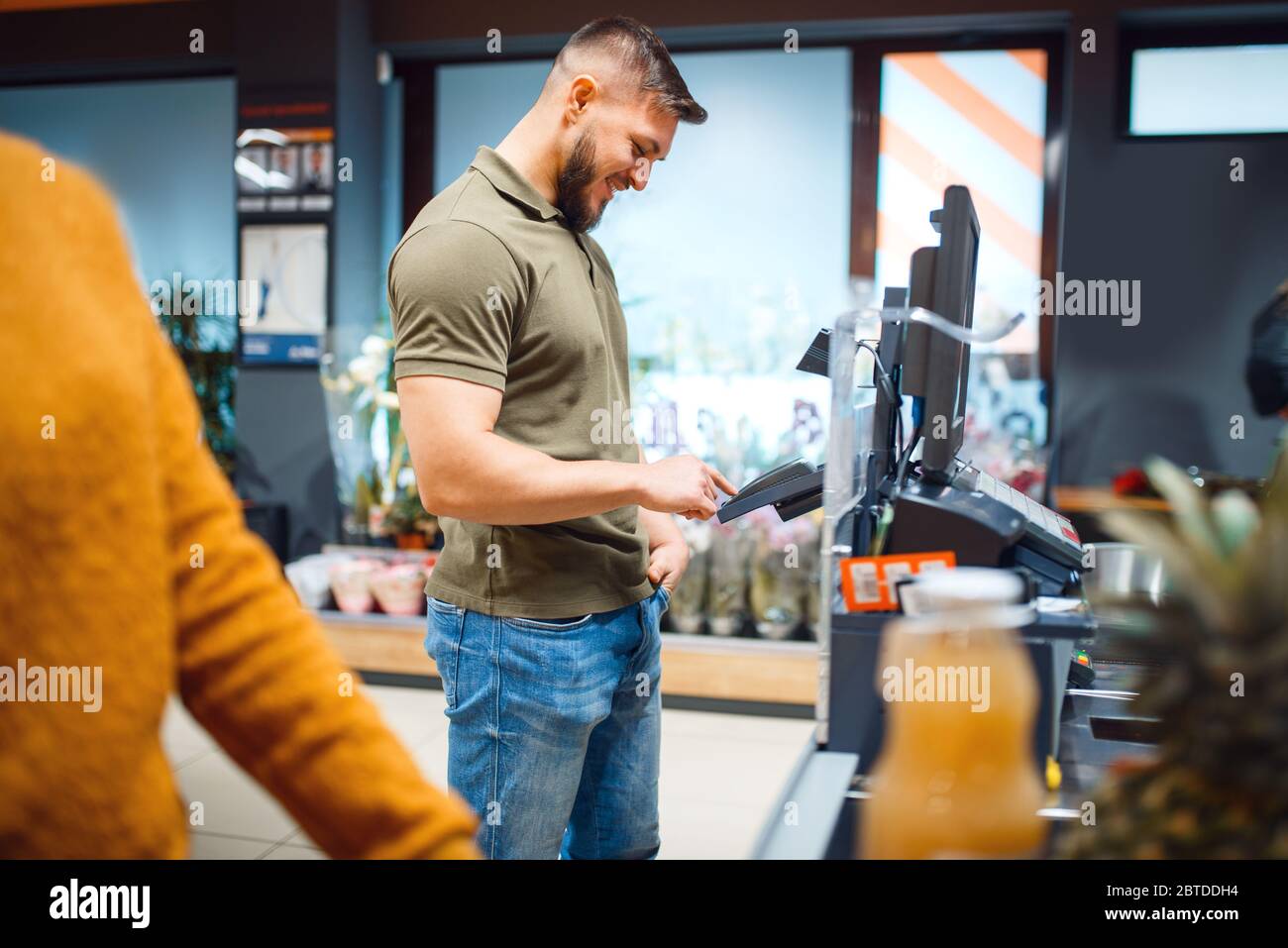 Male person pays at the checkout in grocery store Stock Photo - Alamy