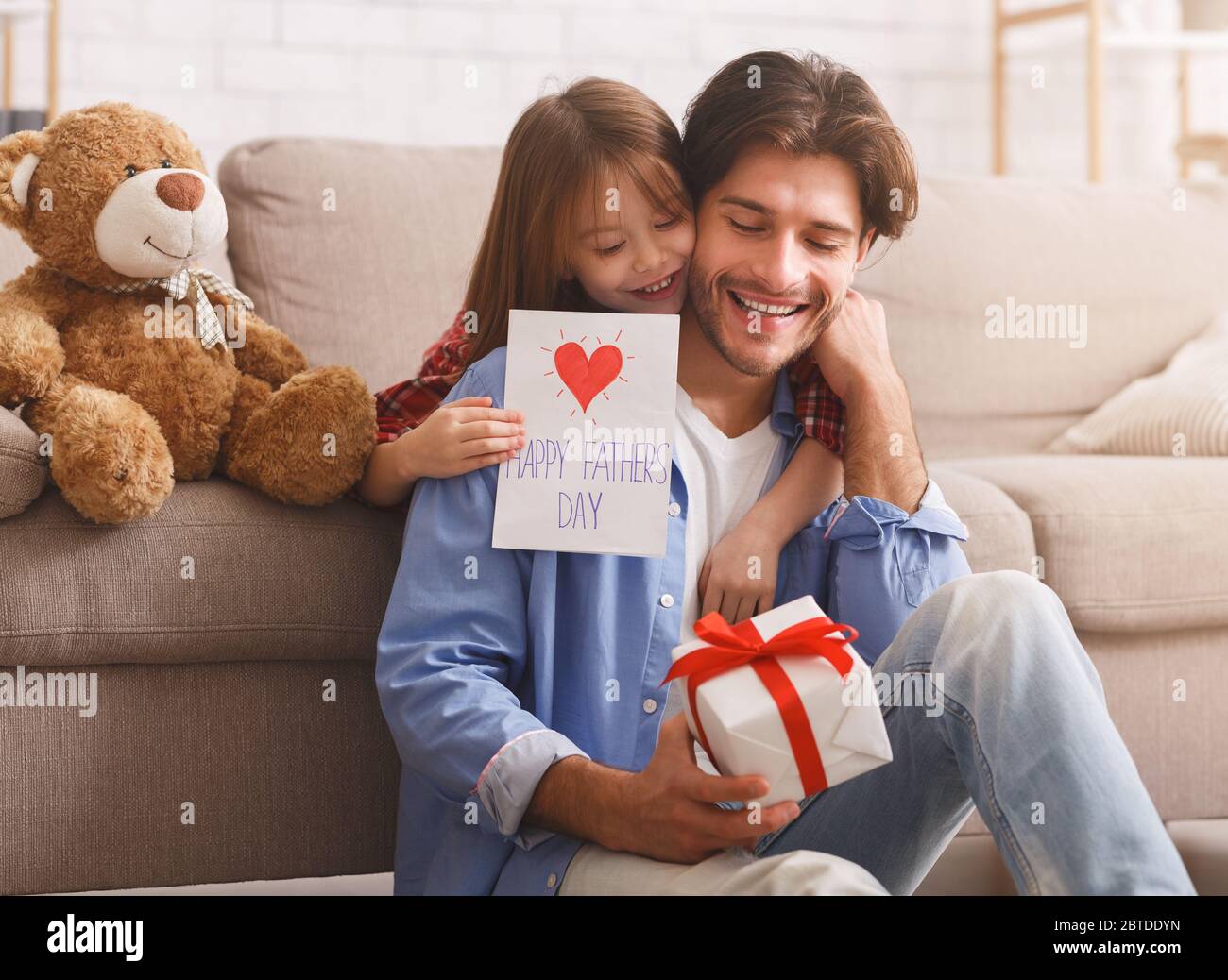 Cute little girl surprising her dad with present Stock Photo - Alamy