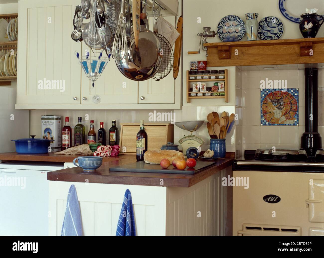 Pans on rack above worktop in kitchen with cream Aga Stock Photo - Alamy