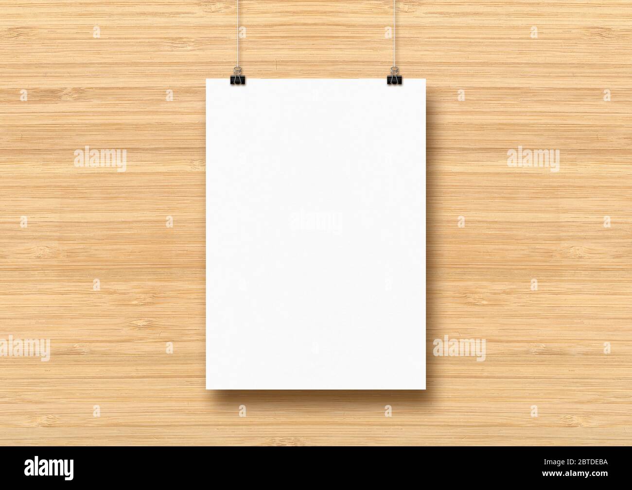 White poster hanging on a wooden wall with clips. Blank mockup template ...