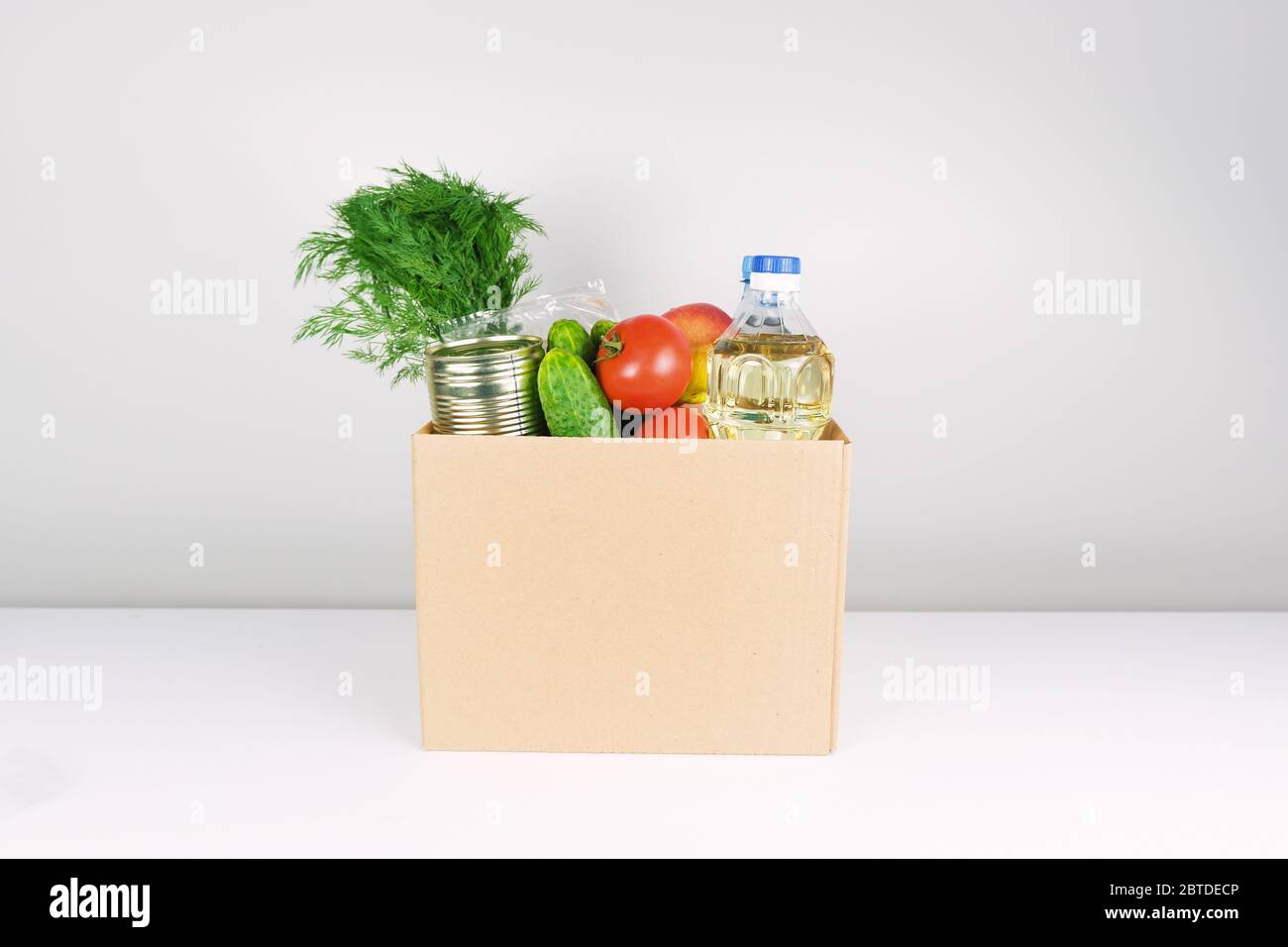 Donation box with food, open card box with oil, apples, cucumbers ...