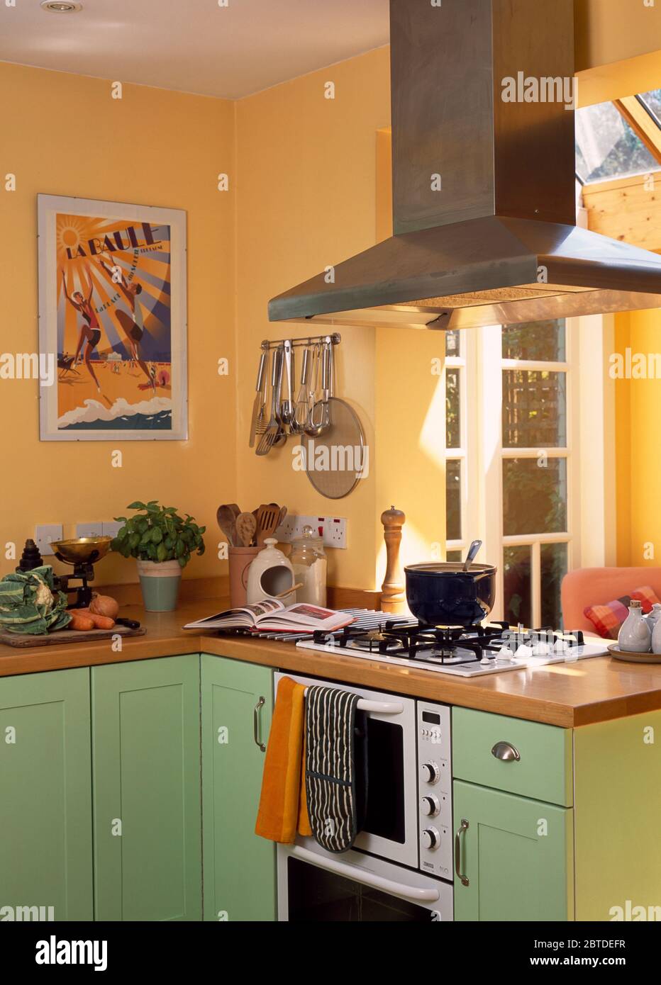 Stainless steel extractor above hob in turquoise kitchen units Stock ...
