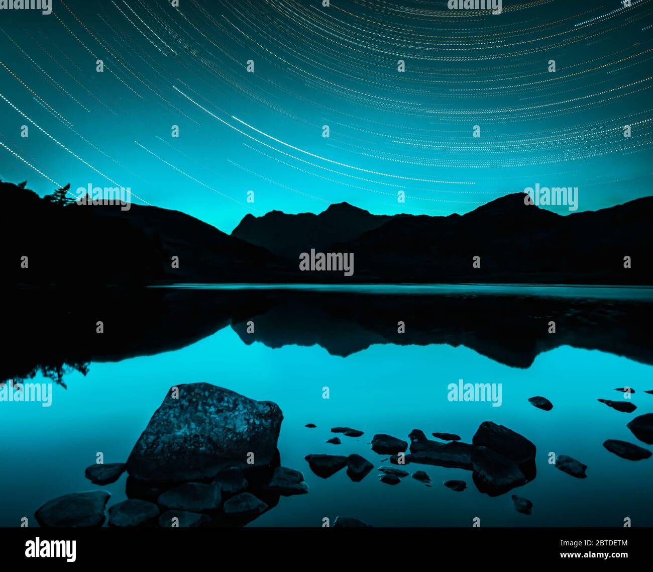 Star trails above mountain lake.Beautiful night scene with sky full of ...