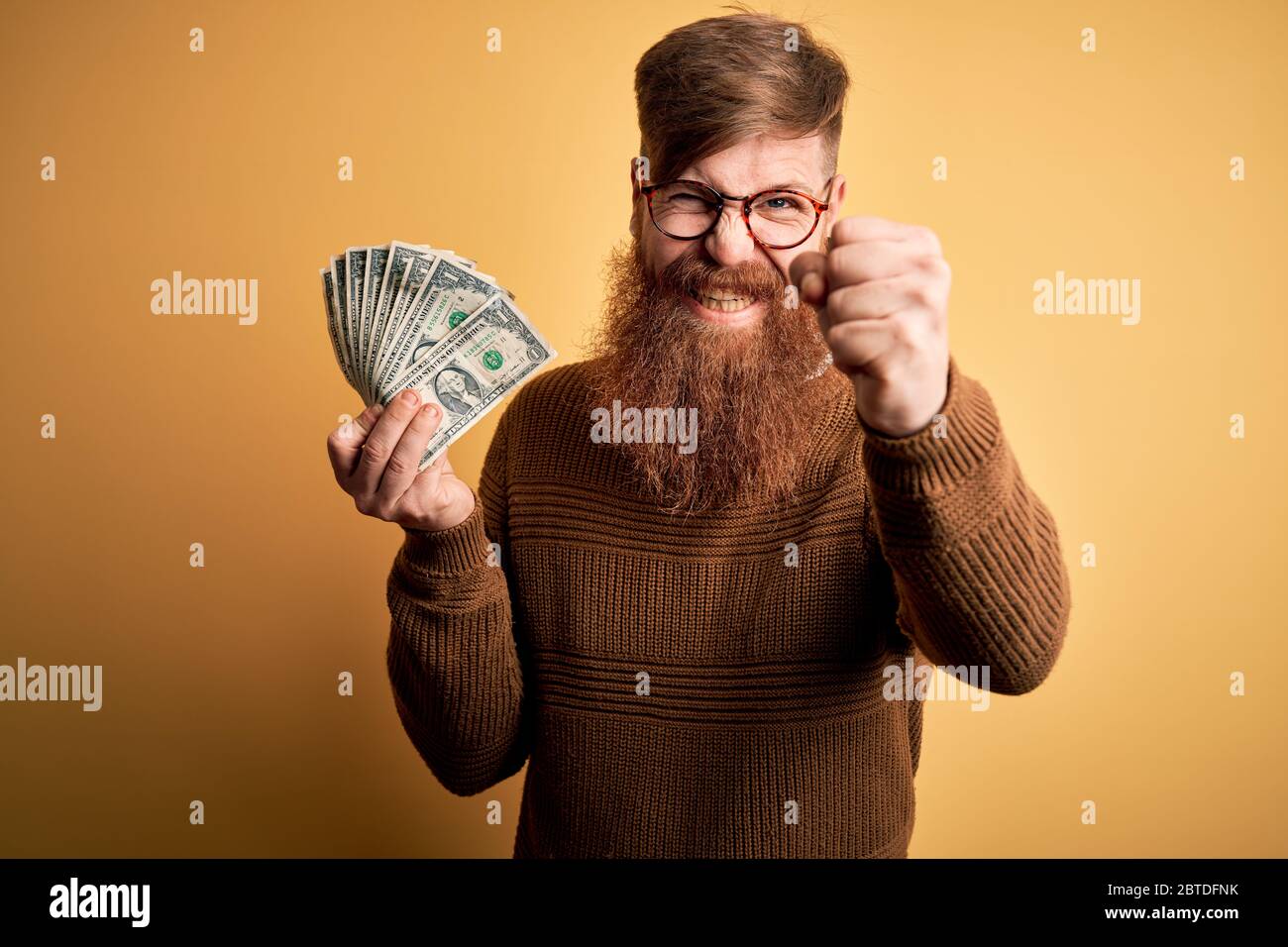 Redhead Irish man with beard holding a bunch of 1 dolla banknotes over ...