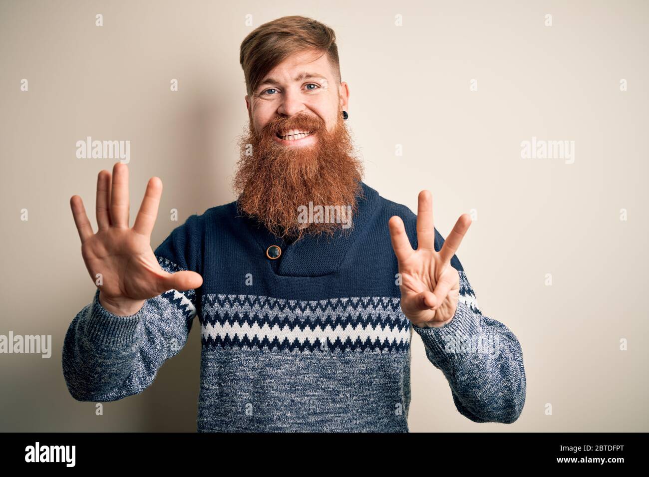 Handsome Irish redhead man with beard wearing winter sweater over ...