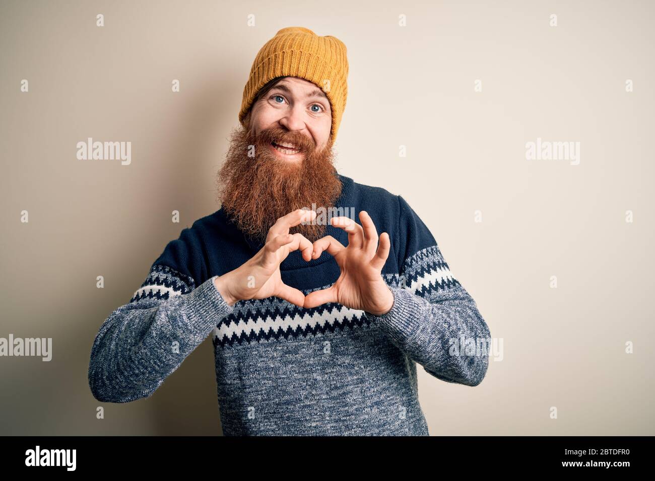 Handsome Irish redhead man with beard wearing winter sweater and wool ...