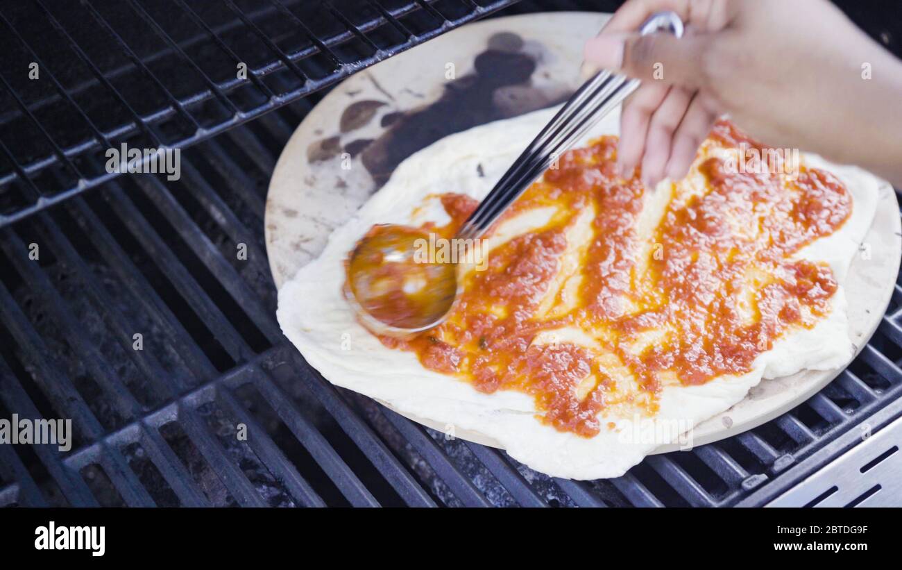 Cooking pizza on outdoor gas grill Stock Photo - Alamy