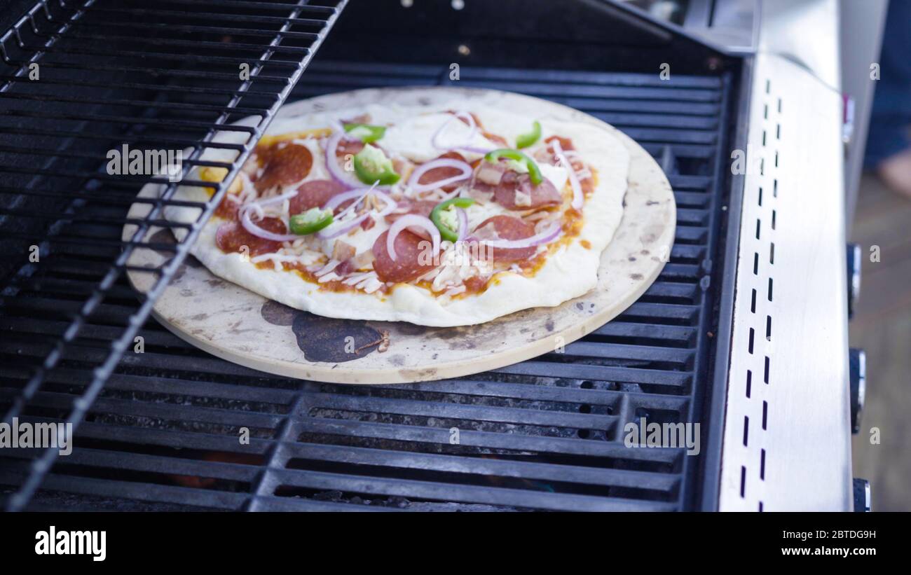 Cooking pizza on outdoor gas grill Stock Photo - Alamy