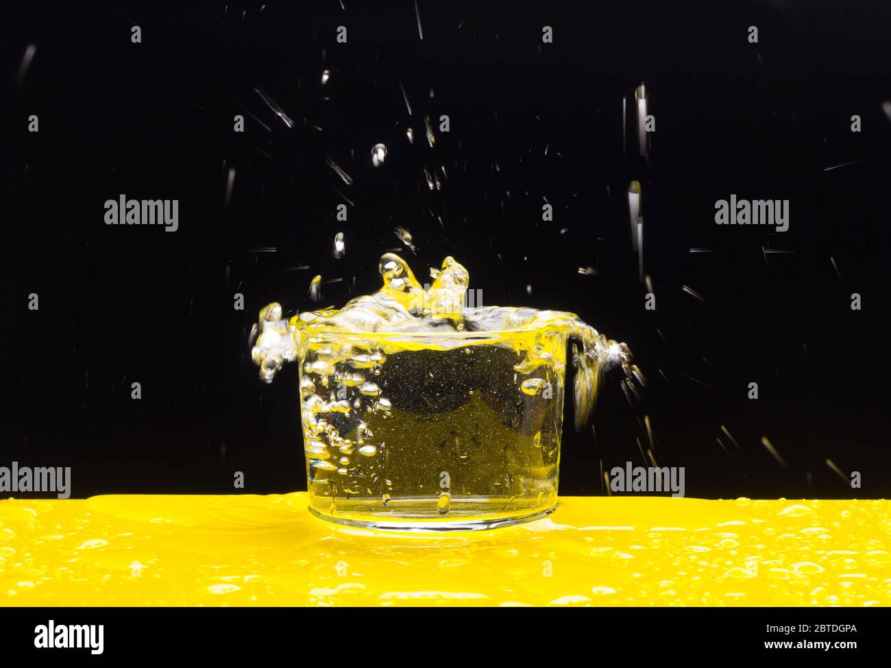 Splash and splash of water in a glass that is filling with fresh, clear ...