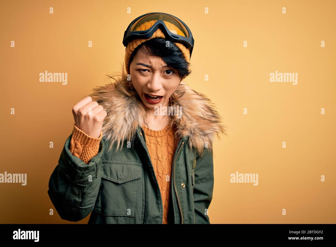 Beautiful asian skier girl wearing snow sportswear using ski goggles ...