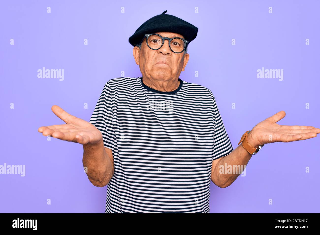 Senior handsome hoary man wearing french beret and glasses standing ...