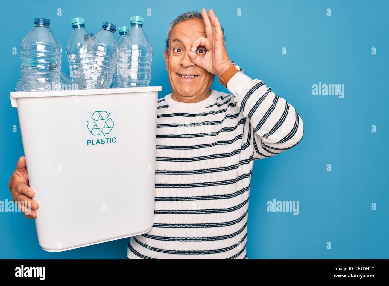 Senior man recycling holding trash can with plastic bottles to recycle ...