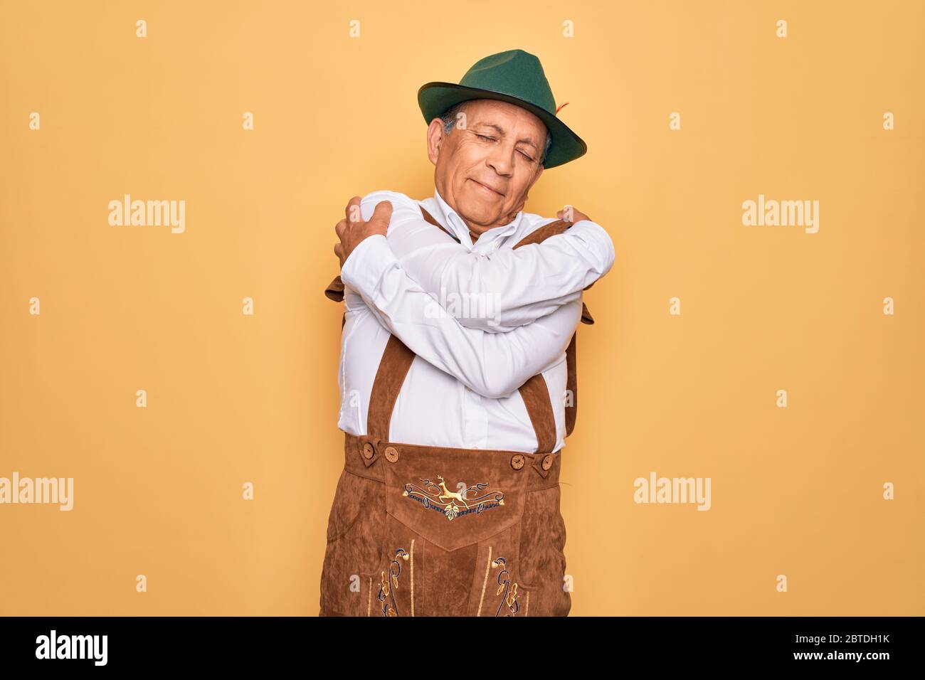 Senior grey-haired man wearing german traditional octoberfest suit over ...