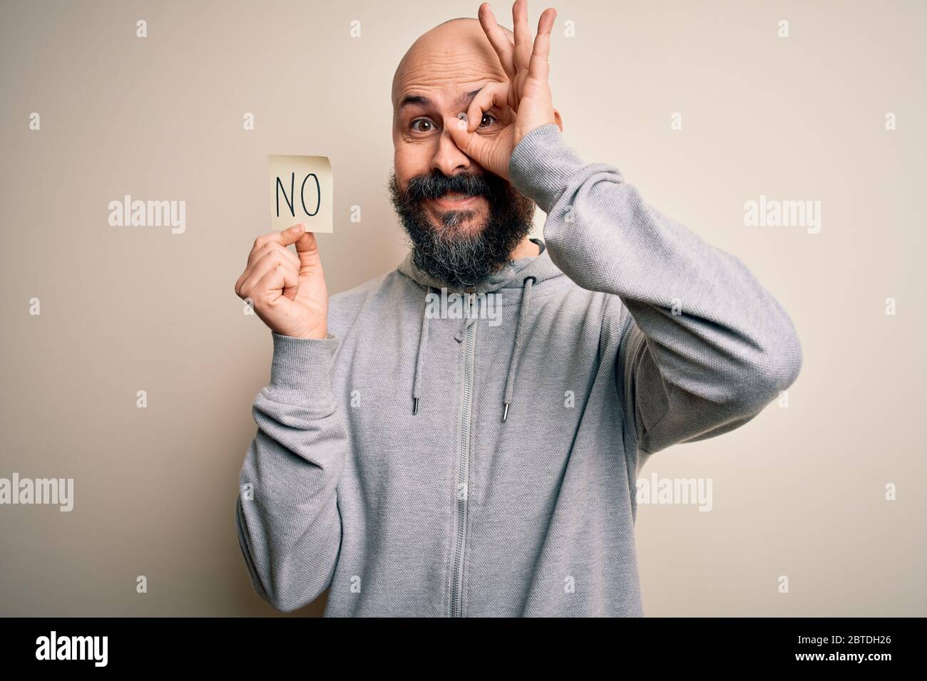 Handsome bald man with beard holding reminder paper with negative ...