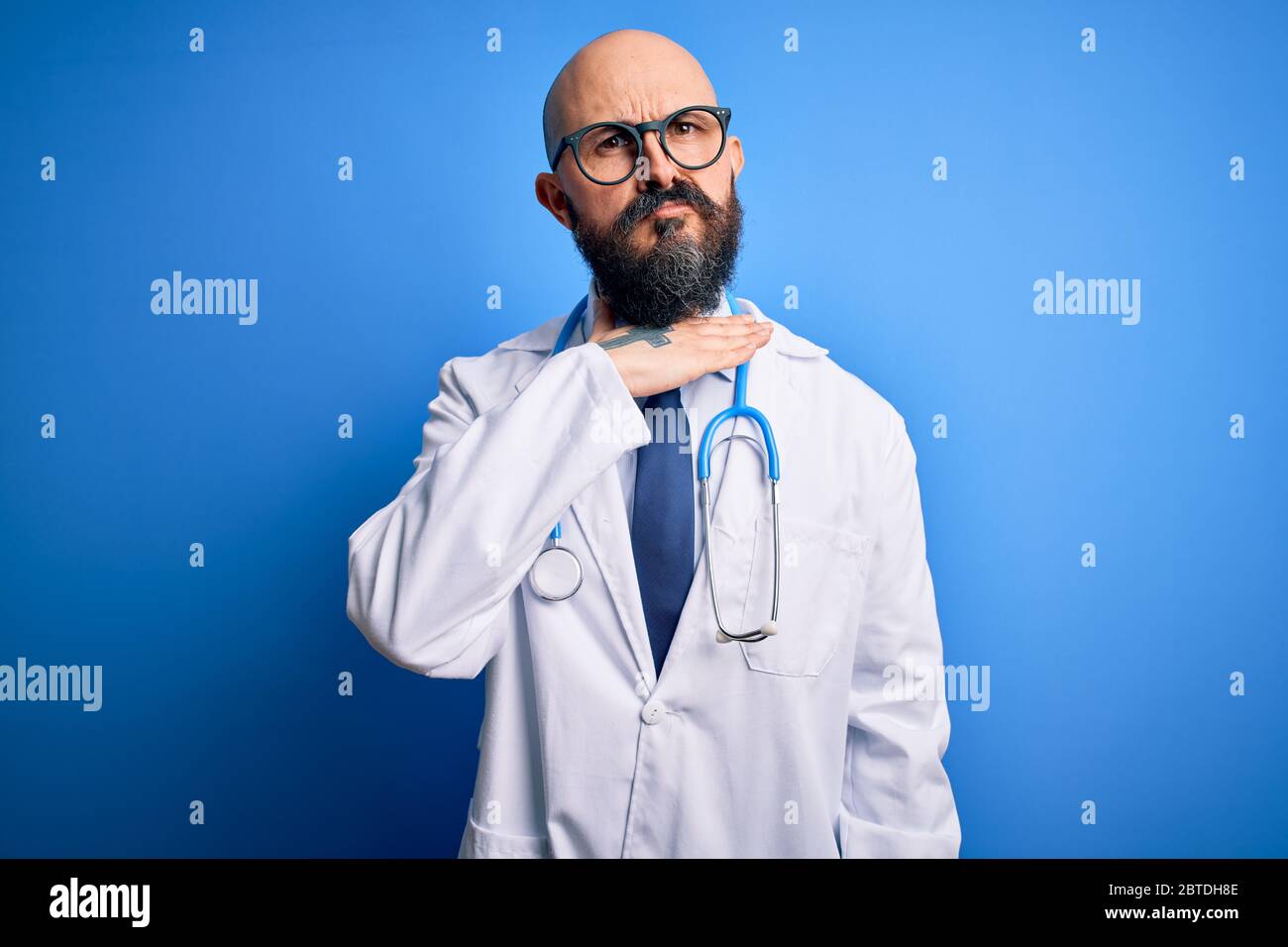 Handsome bald doctor man with beard wearing glasses and stethoscope ...