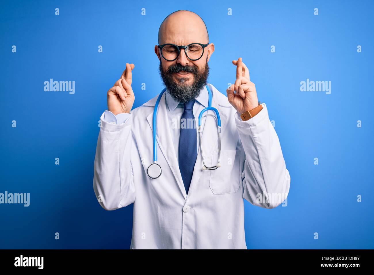 Handsome bald doctor man with beard wearing glasses and stethoscope ...