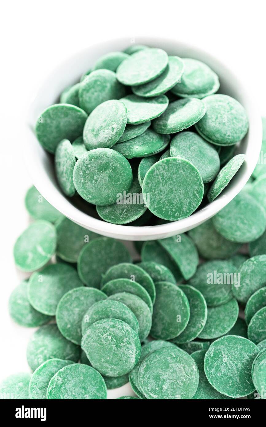 Green round chocolate chips for melting chocolate shapes on a white ...