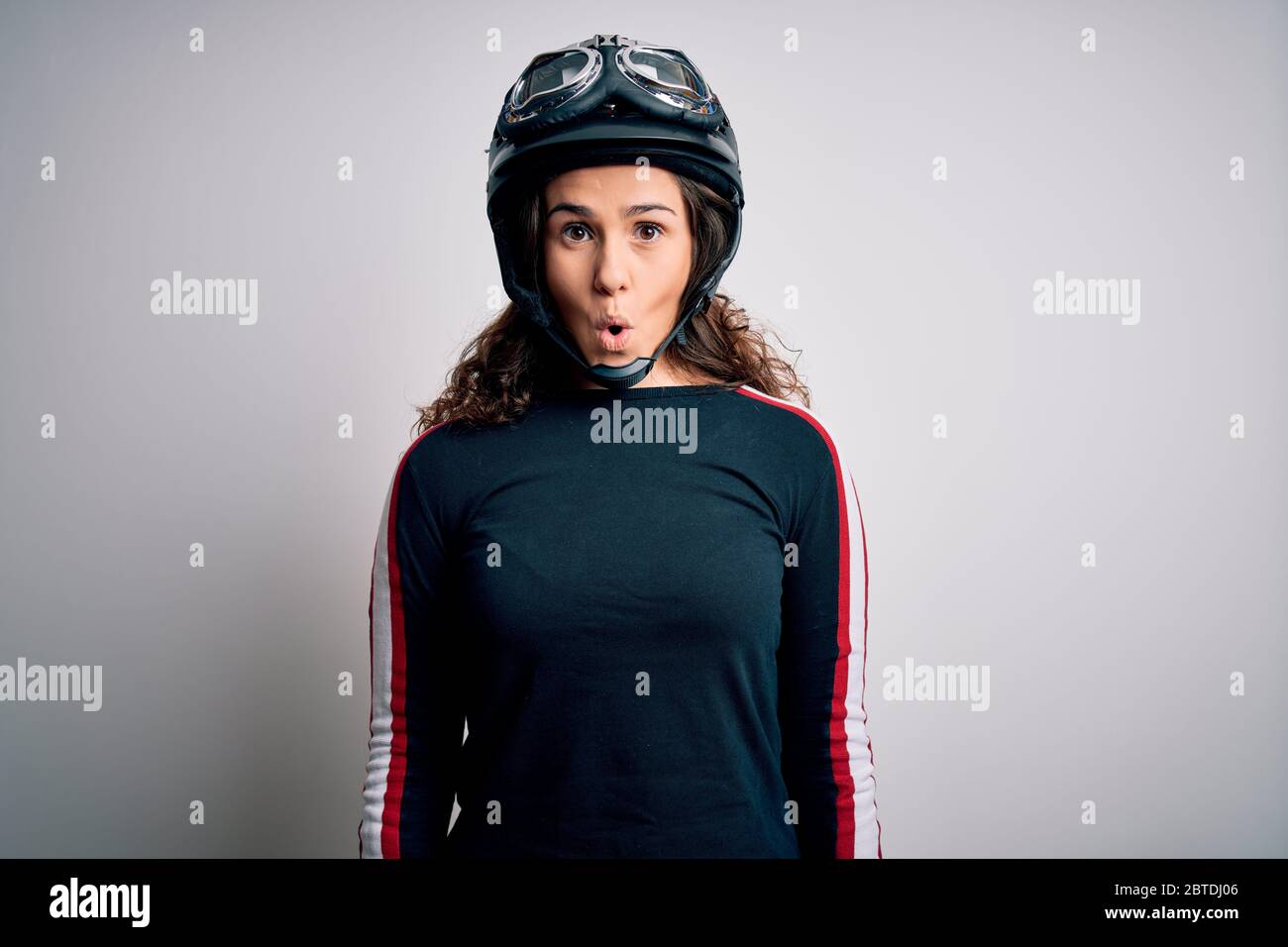 Beautiful motorcyclist woman with curly hair wearing moto helmet over ...