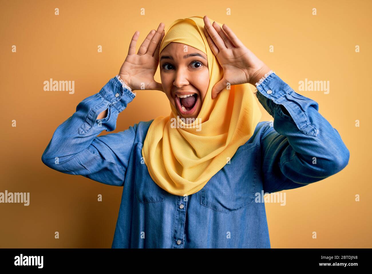 Young beautiful woman with curly hair wearing arab traditional hijab ...