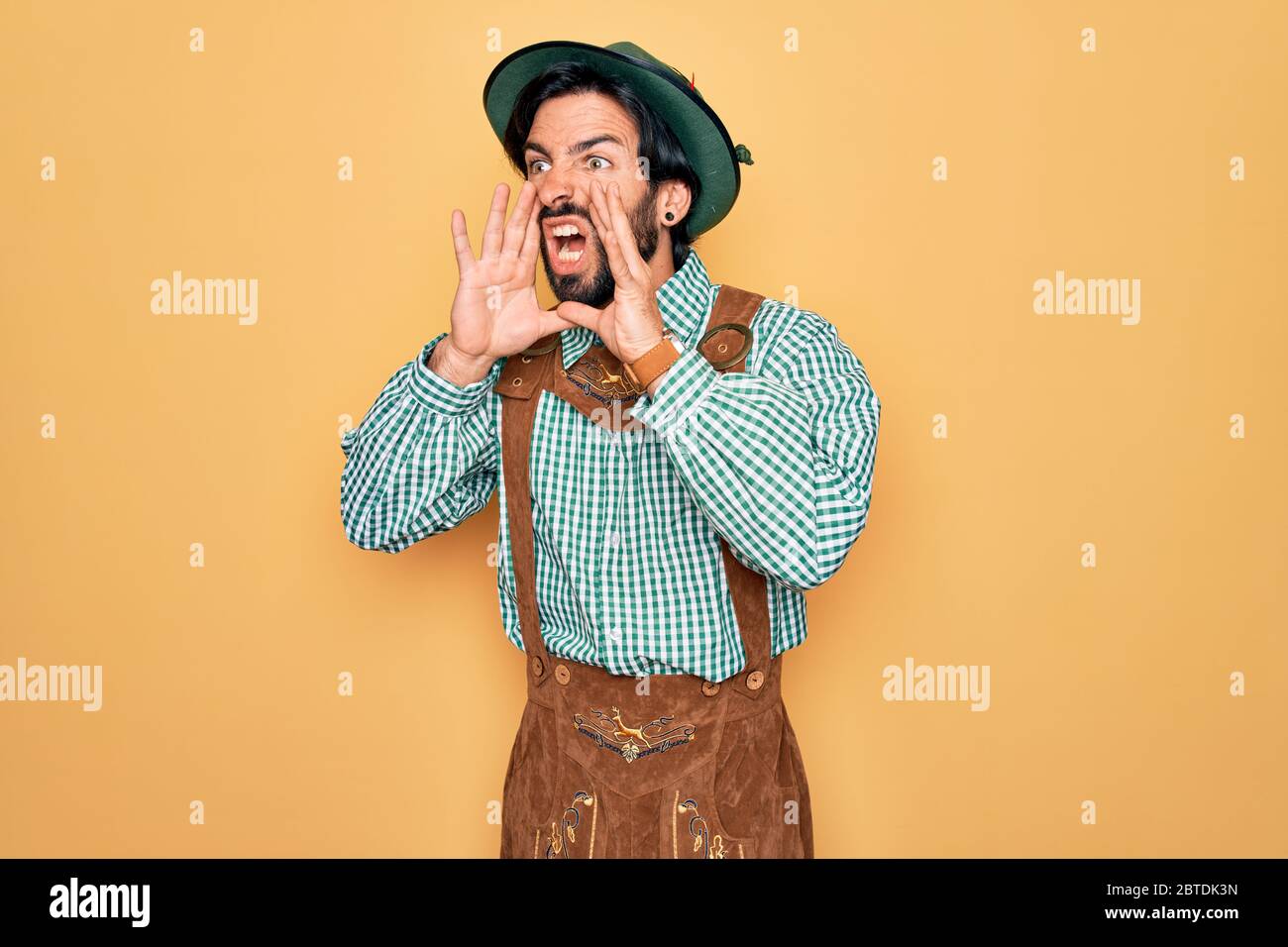 Young handsome man wearing tratidional german octoberfest custome for Germany festival Shouting ...
