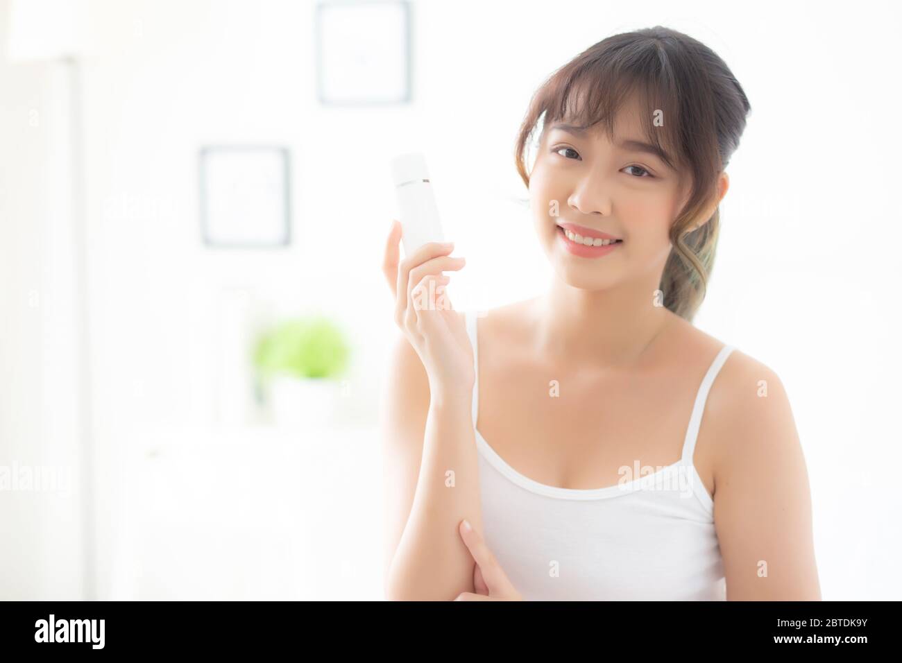 Beautiful portrait young asian woman holding and presenting cream or ...