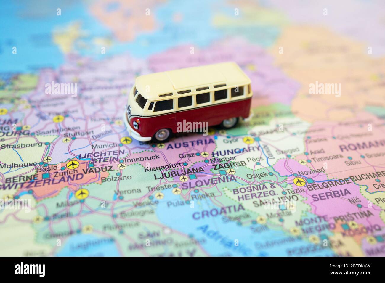 Small toy retro bus in the middle of Europe map. Travel by minivan ...