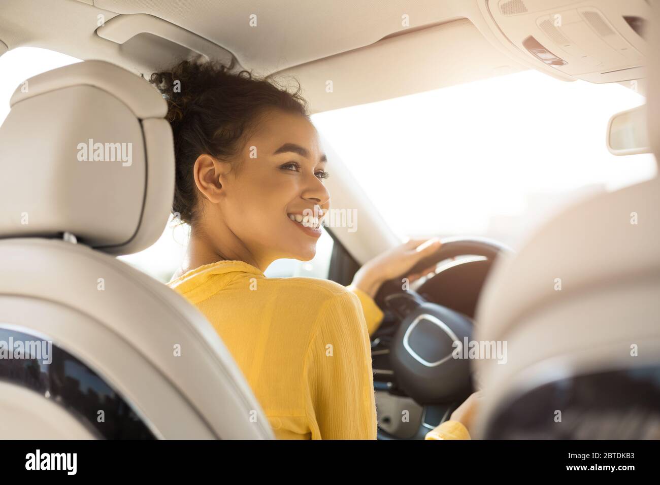 Cheerful Black Woman Driving Car Sitting In Automobile, Back View Stock ...