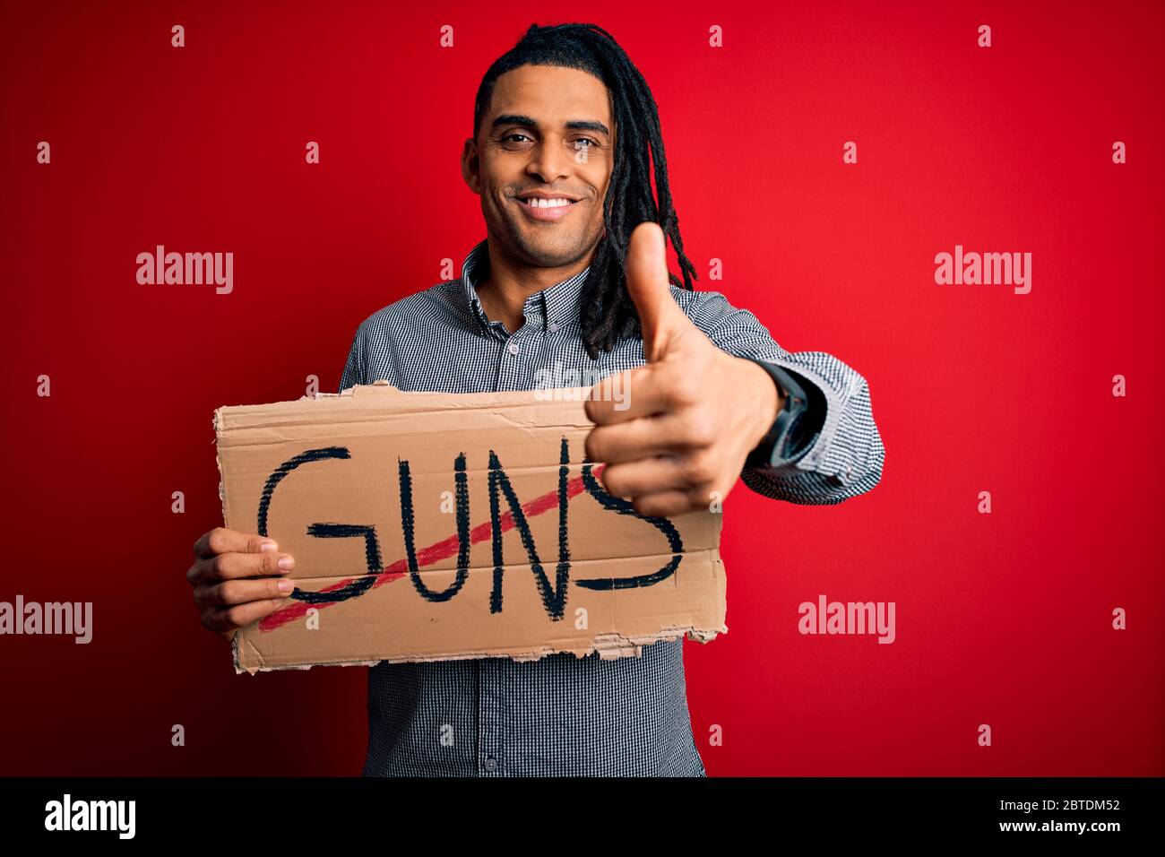 Young african american man with dreadlocks holding banner doing ...