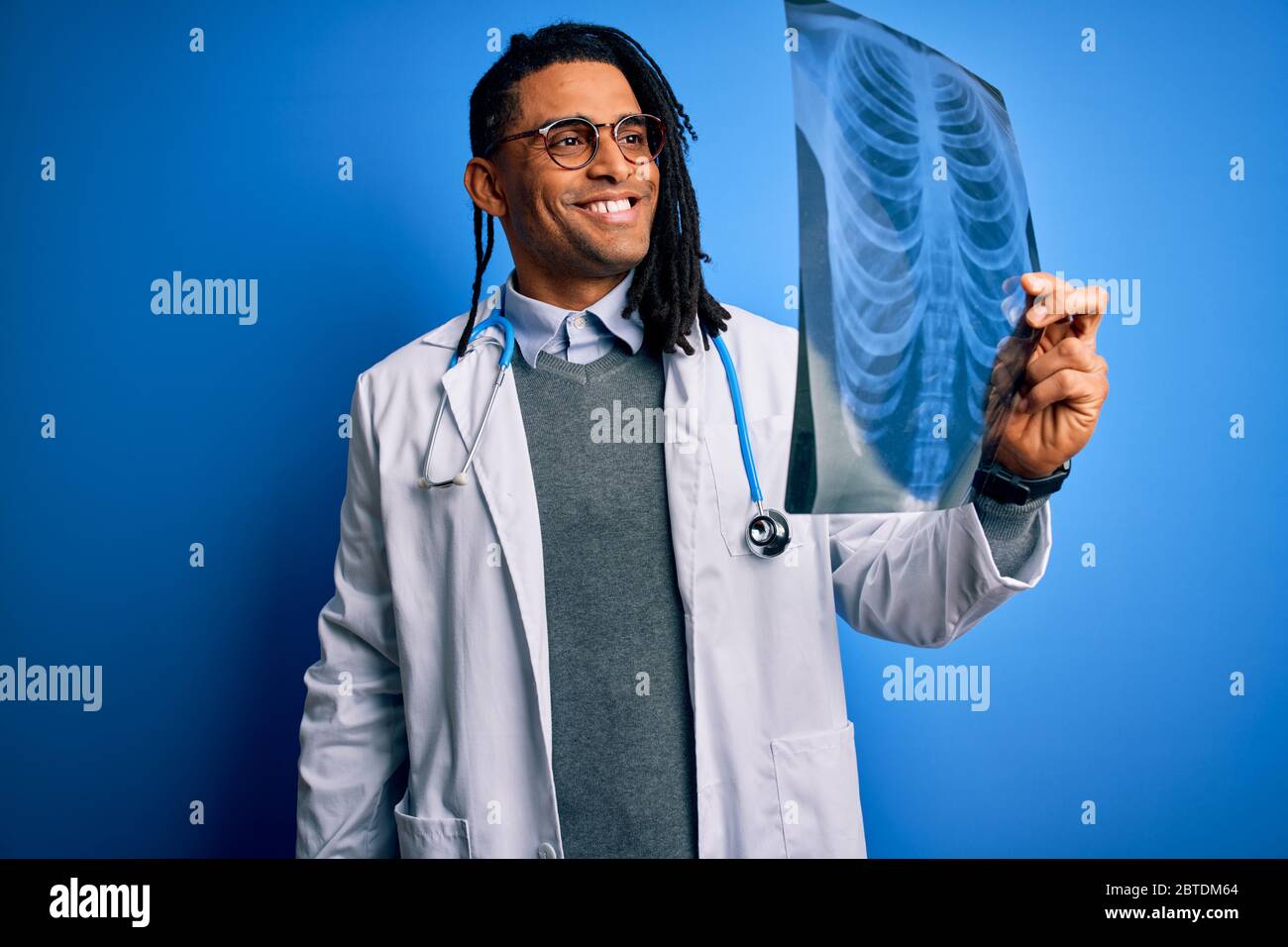 Young african american afro doctor man with dreadlocks holding chest ...