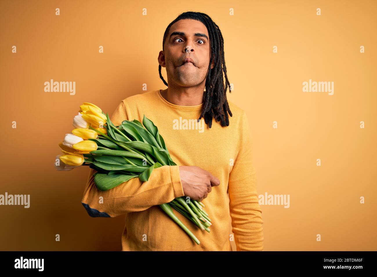 Young african american afro romantic man with dreadlocks holding ...