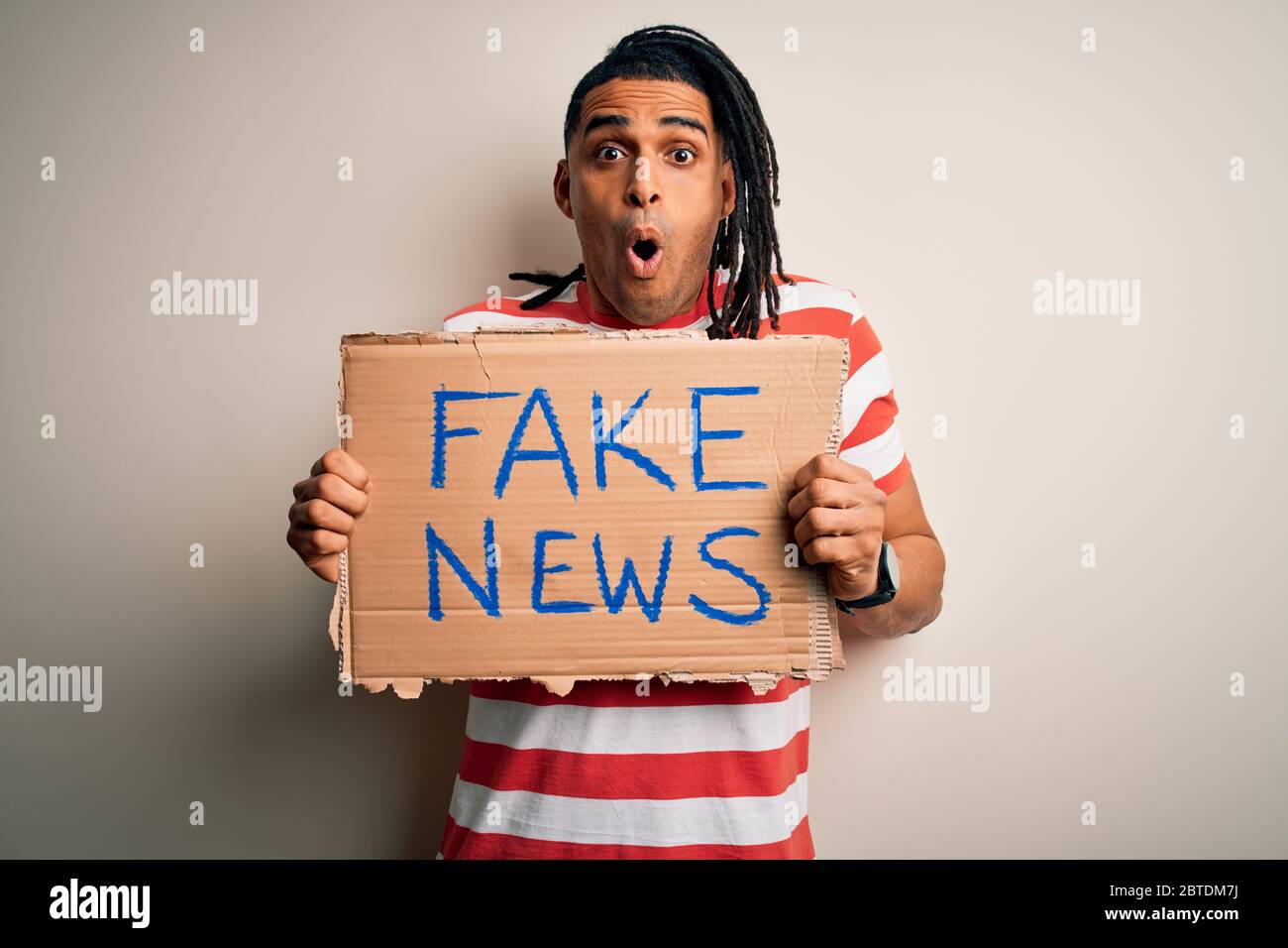Young african american man with dreadlocks holding banner with fake ...
