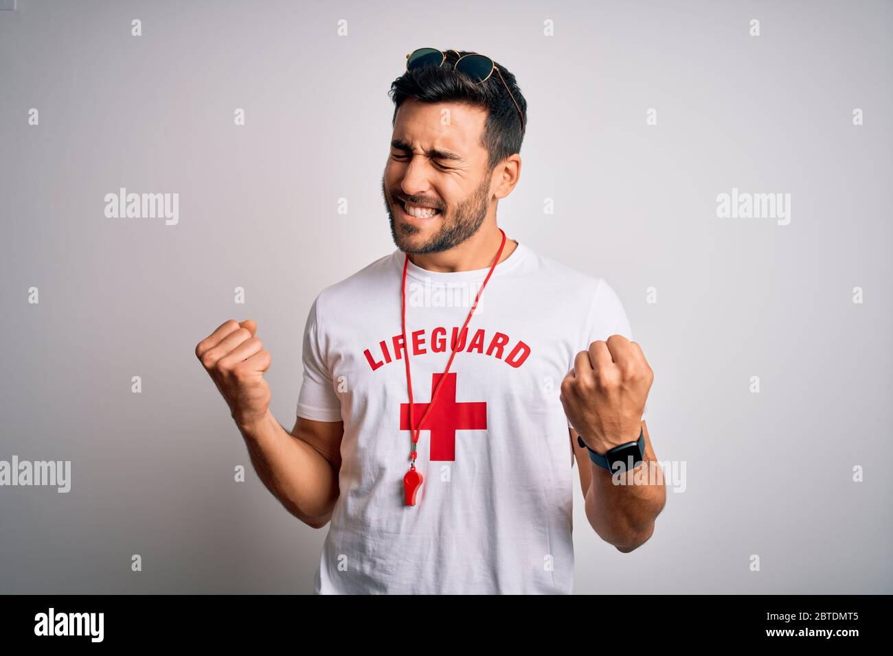 Young handsome lifeguard man with beard wearing t-shirt with red cross ...