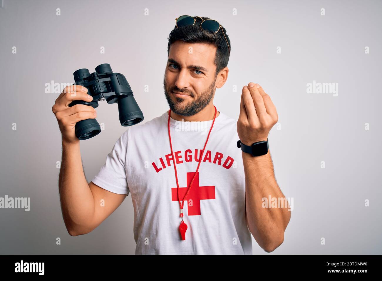 Young lifeguard man with beard wearing t-shirt with red cross and ...
