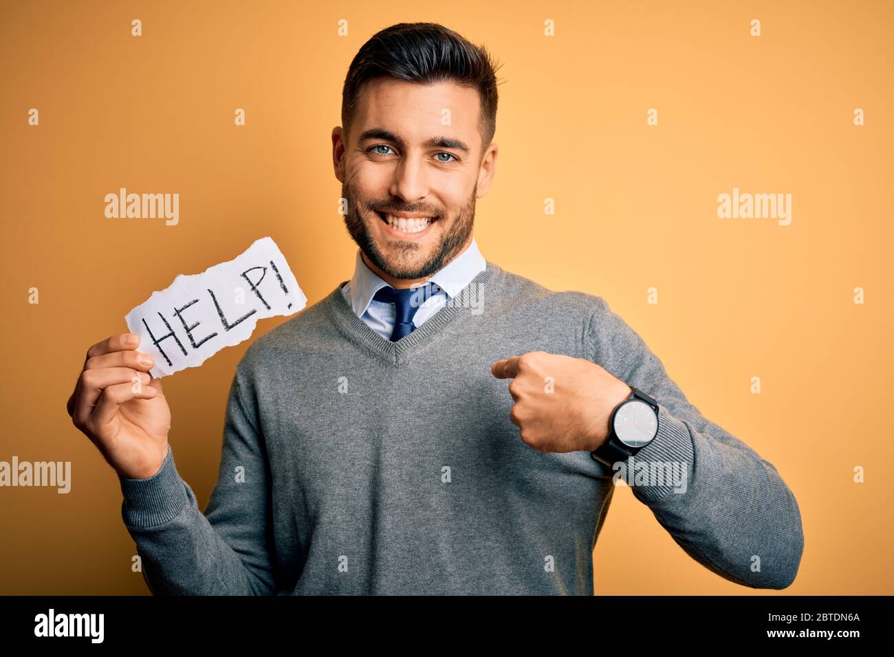 Young overworked business man asking for help holding paper over yellow ...