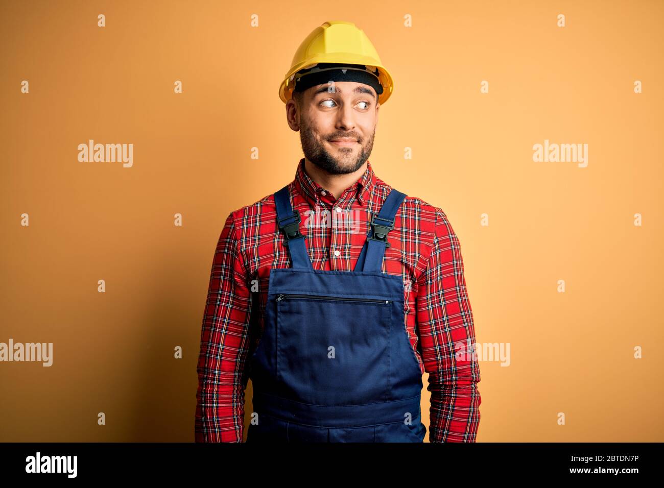 Young builder man wearing construction uniform and safety helmet over ...
