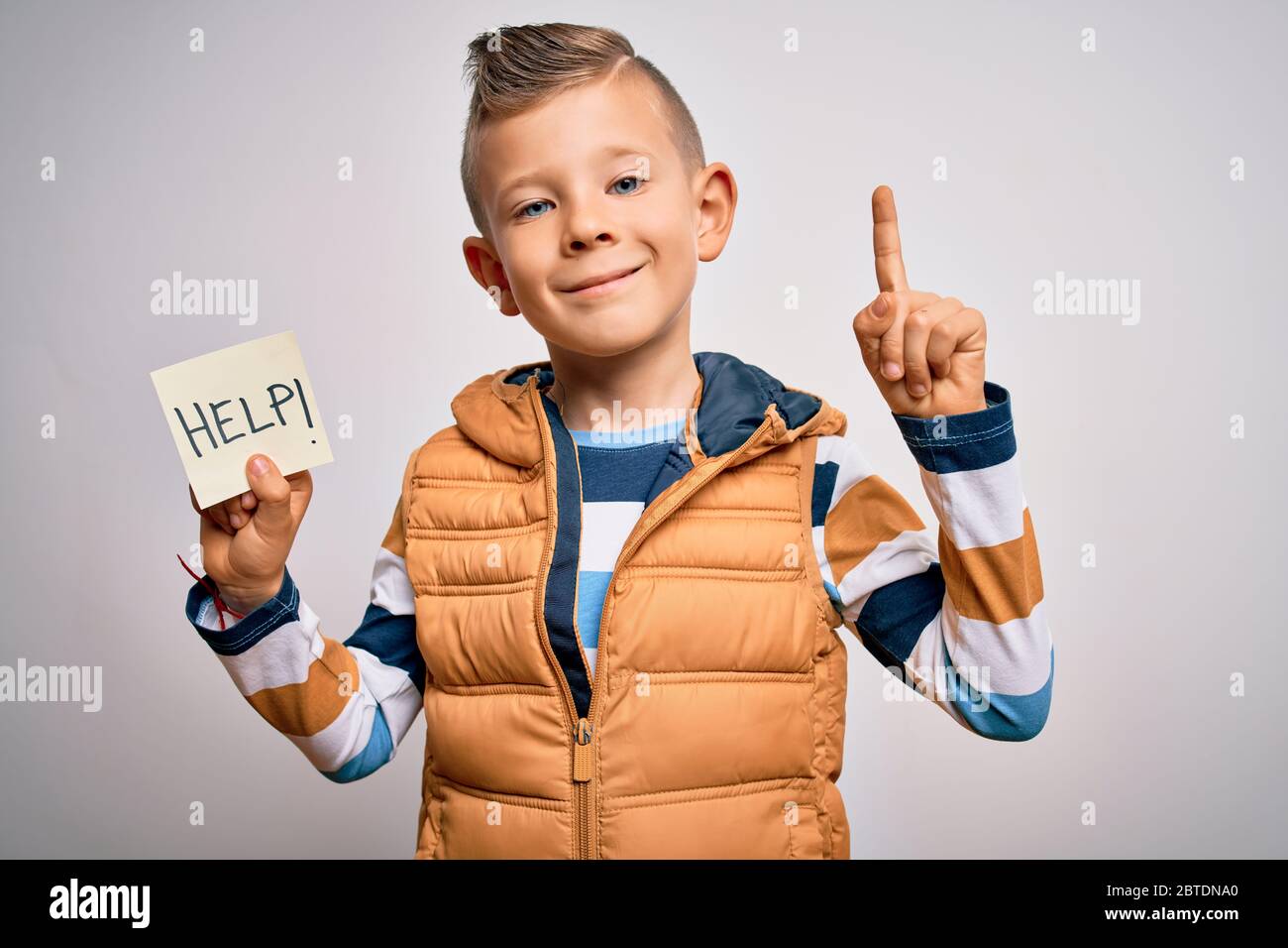 Young little caucasian kid asking for help on a paper note as violence ...
