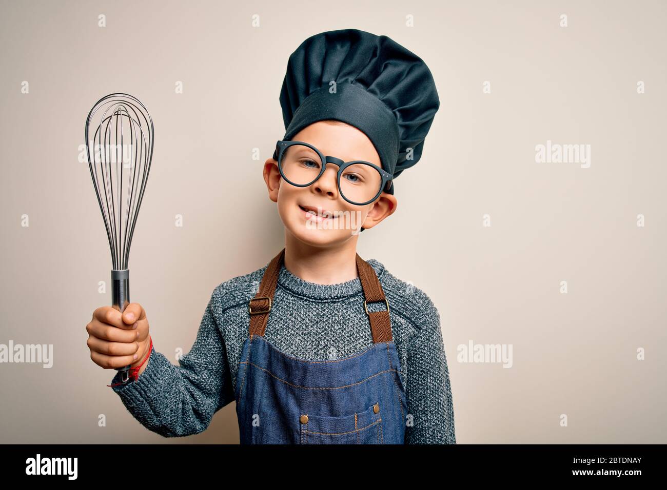 Young little caucasian cook kid wearing chef uniform and hat using ...