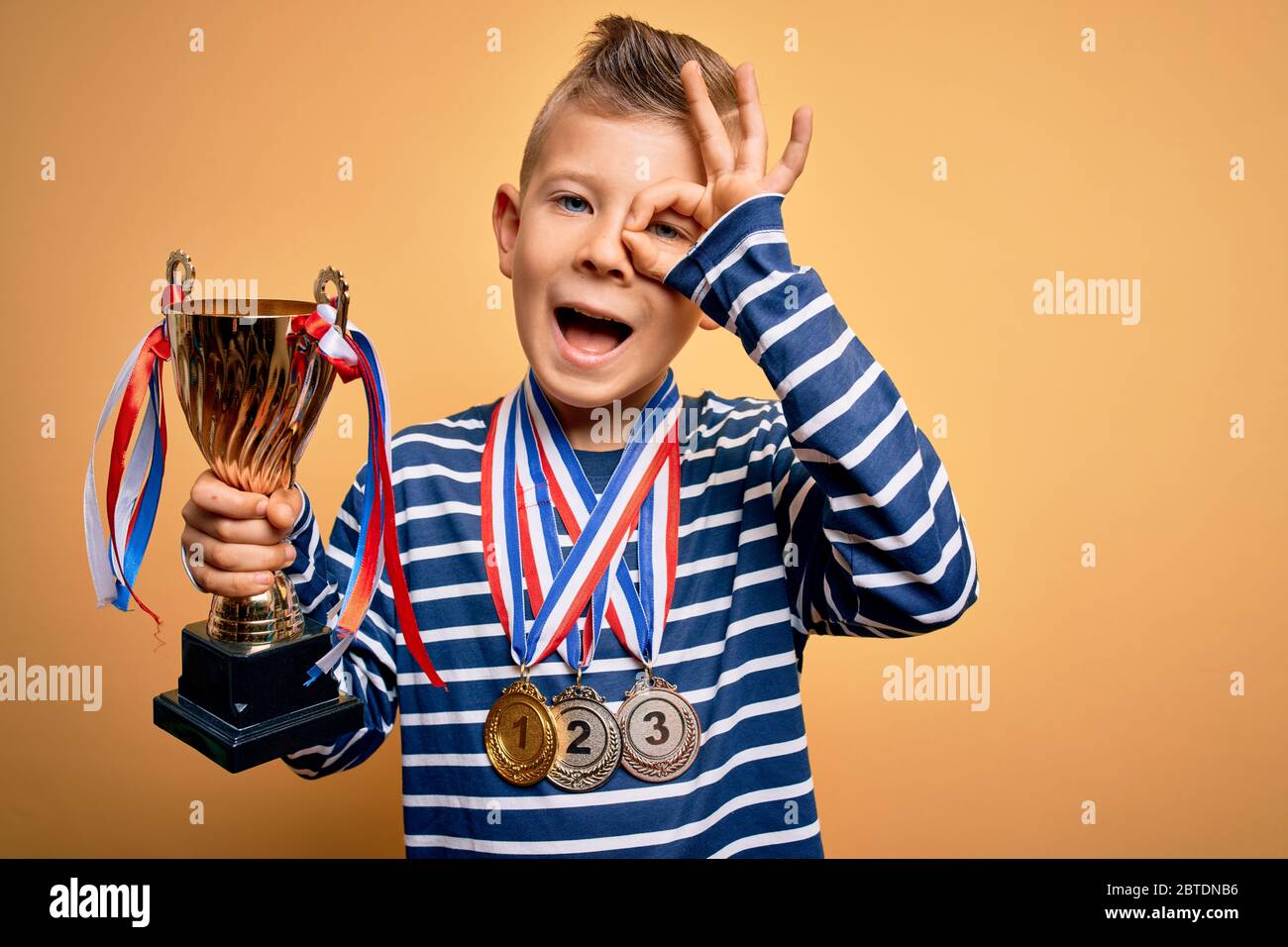 Young little caucasian kid wearing winner medals and victory award ...