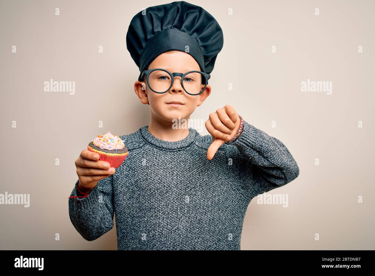 Young little caucasian cook kid wearing chef uniform and hat cooking ...