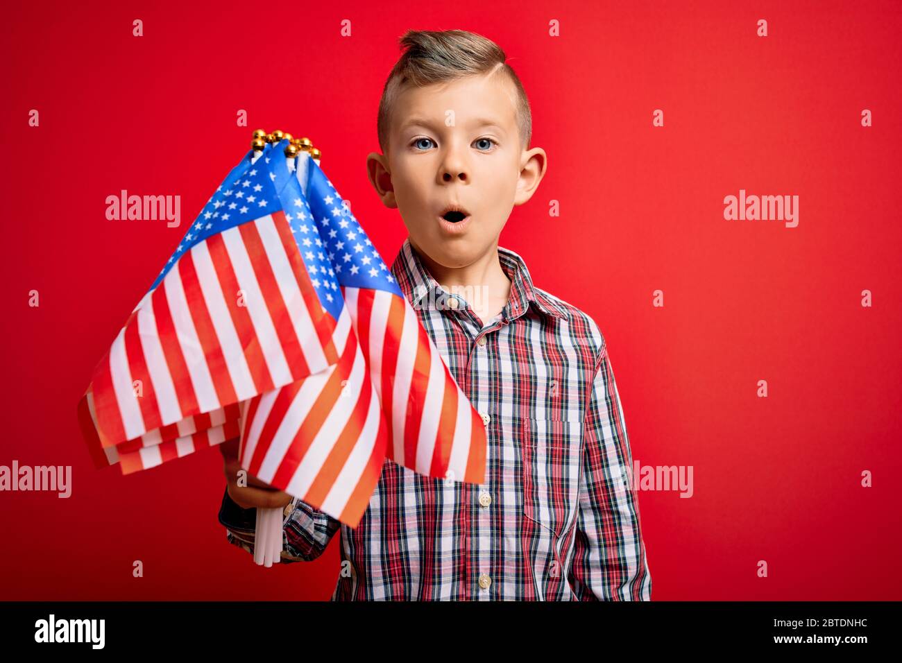 Young little american patriotic caucasian kid holding flag of USA over ...