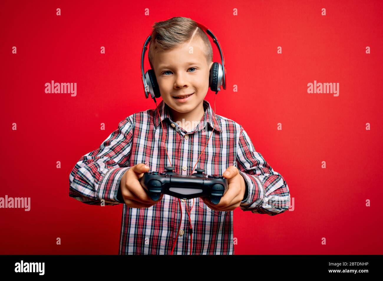 Young little caucasian gamer kid playing video games using gamepad ...