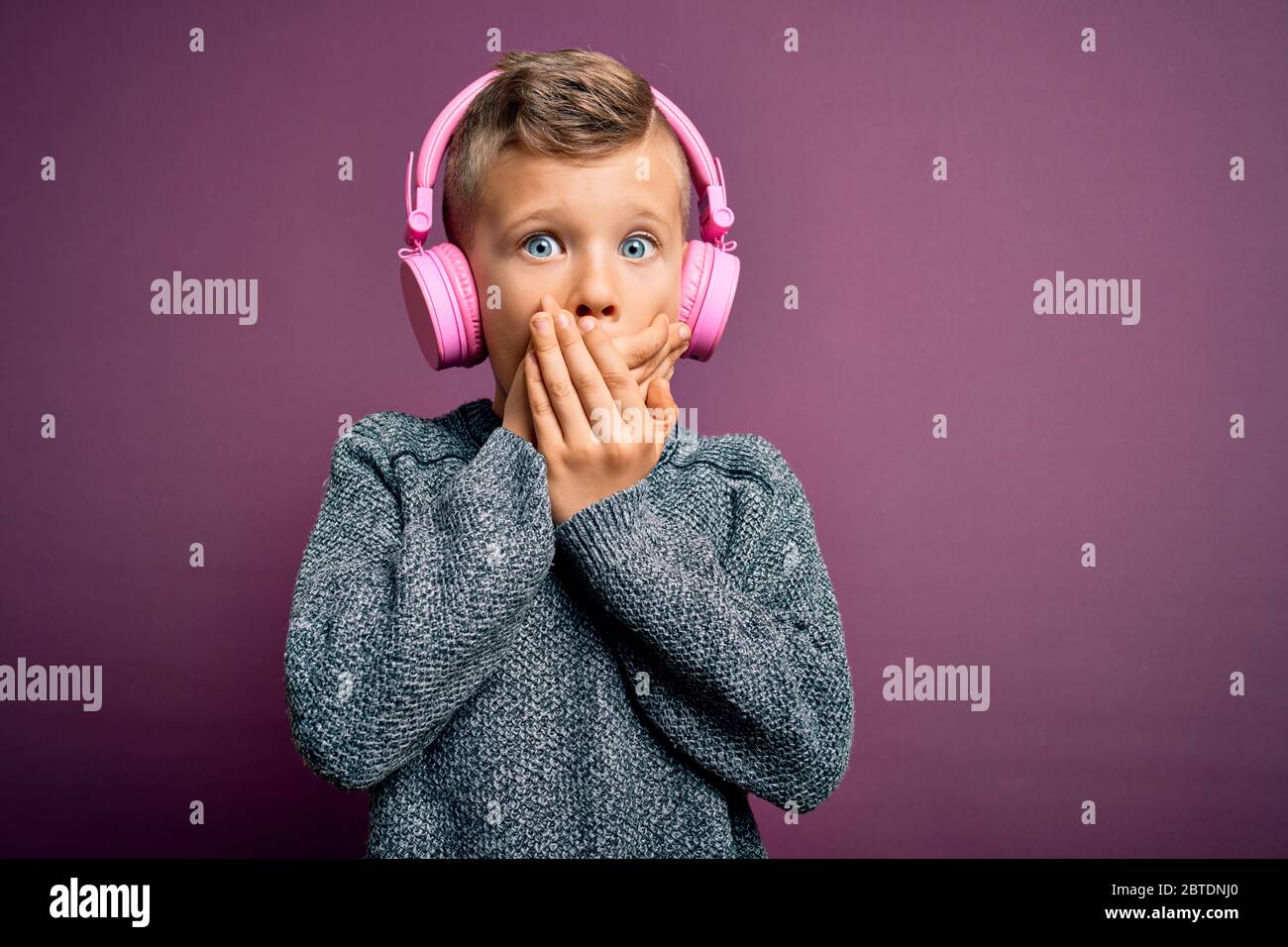 Young little caucasian kid wearing headphones listening to music over ...