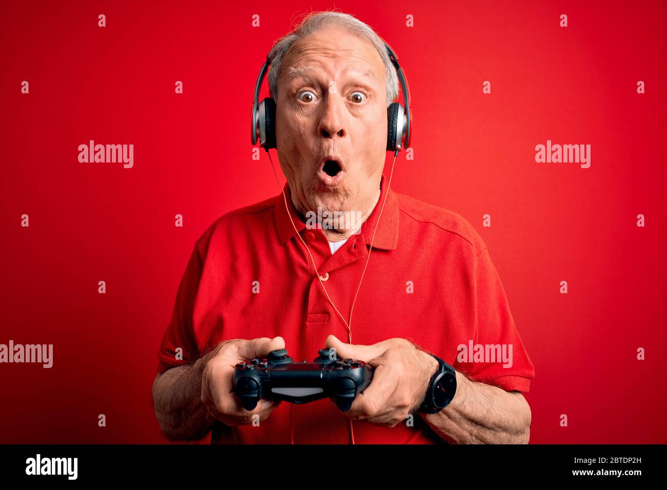 Senior grey haired gamer man playing video games using gamepad joystick ...