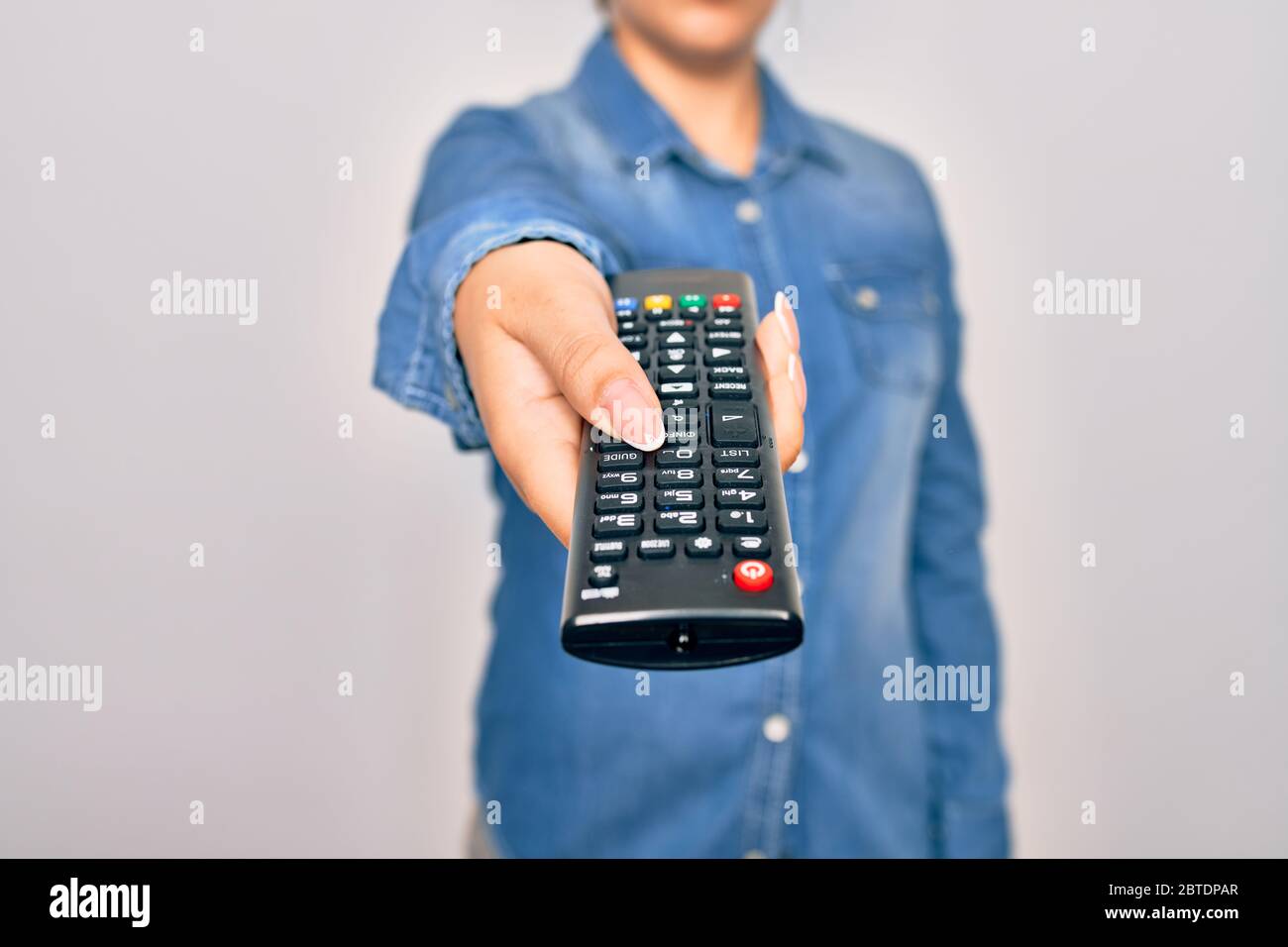 Woman changing television channel holding tv remote control. Standing ...