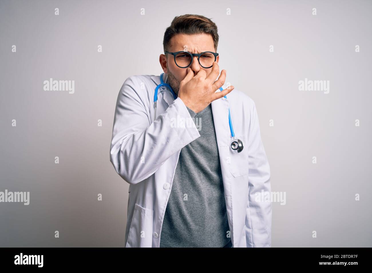 Young doctor man with blue eyes wearing medical coat and stethoscope ...