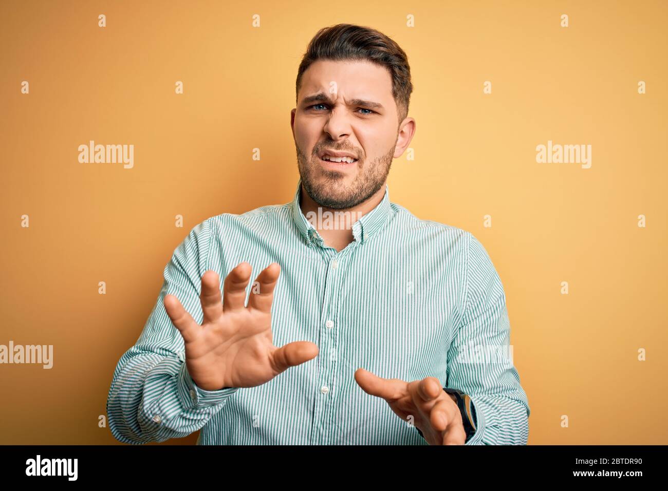 Young business man with blue eyes wearing elegant green shirt over ...